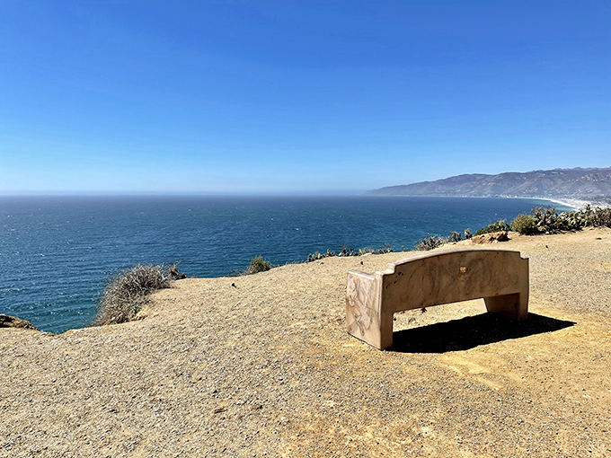 The most exclusive seat in Malibu doesn't require reservations. This stone bench offers front-row tickets to nature's greatest show—completely free.