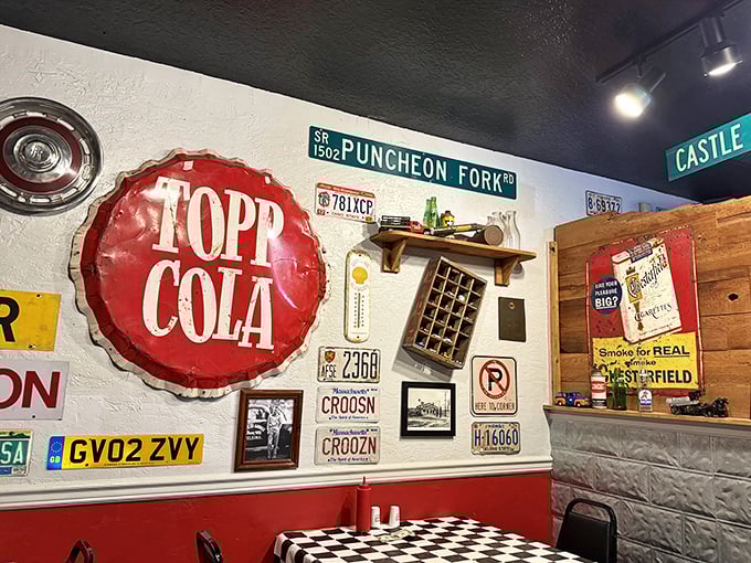 The walls tell stories through vintage signs, license plates, and a Topp Cola sign that predates most of the diners' first cars.