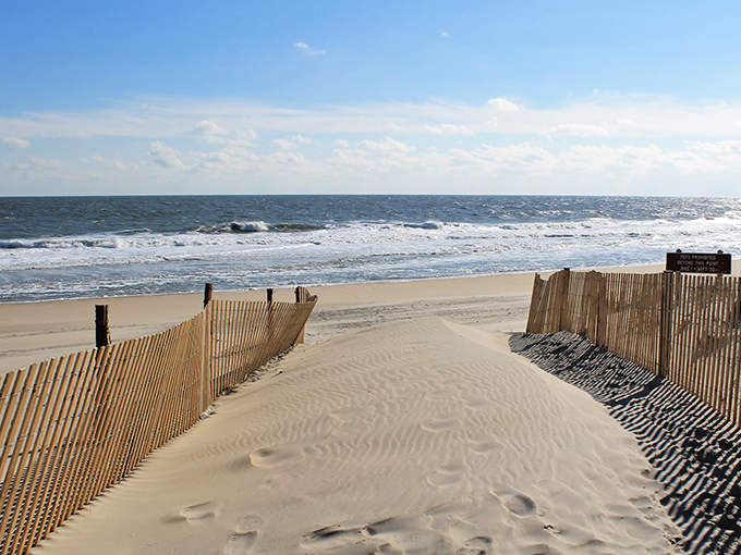 Nature's welcome mat: wind-sculpted sand between wooden sentinels guides visitors toward the rhythm of crashing waves.