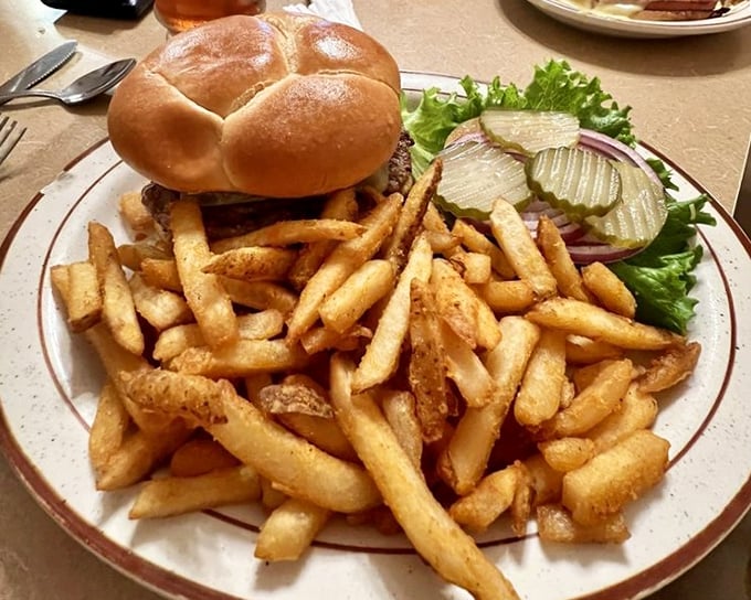 This isn't just a burger—it's architecture. A towering testament to the art of lunch, with fries that could convert a salad-eater.