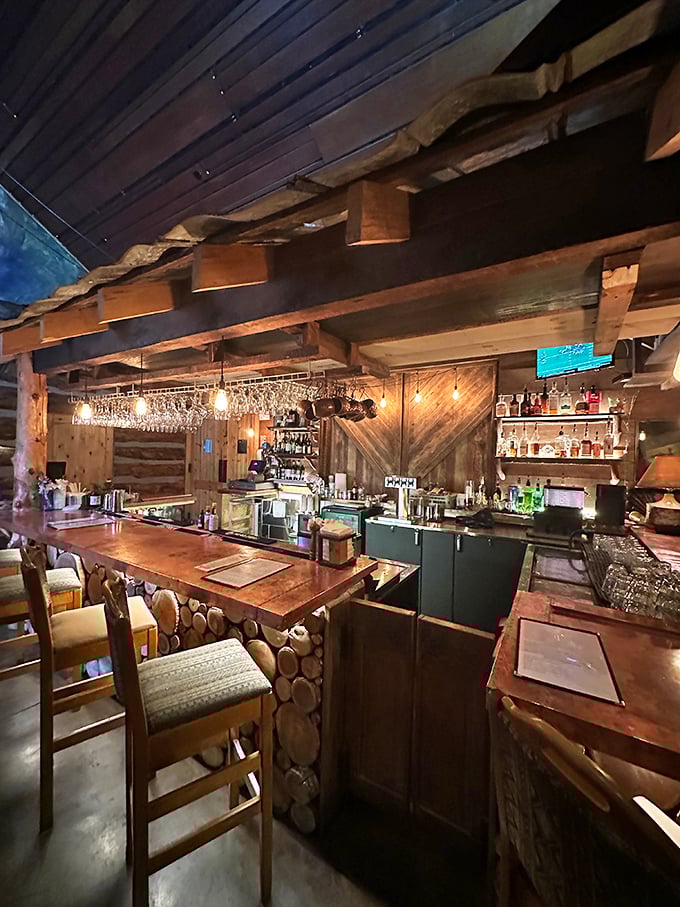 The bar area showcases masterful woodwork and warm lighting. Where bourbon sipping becomes an art form worthy of the surroundings.