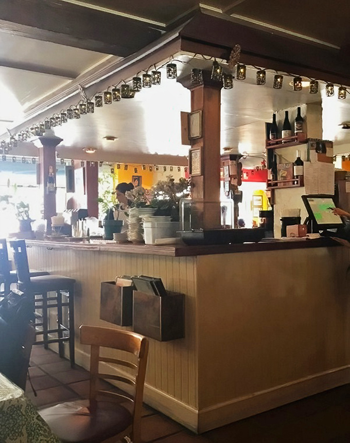 The bar area—where strangers become friends over shared pizza recommendations and wine-fueled debates about toppings.