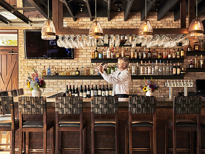 The bar area doesn't just serve drinks—it serves possibilities, all lined up in bottles against that gorgeous exposed brick backdrop.