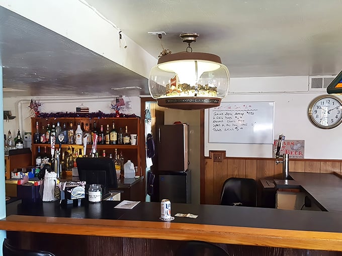 The bar area—where local stories flow as freely as the drinks, under the watchful gaze of a ship-in-a-bottle light fixture.