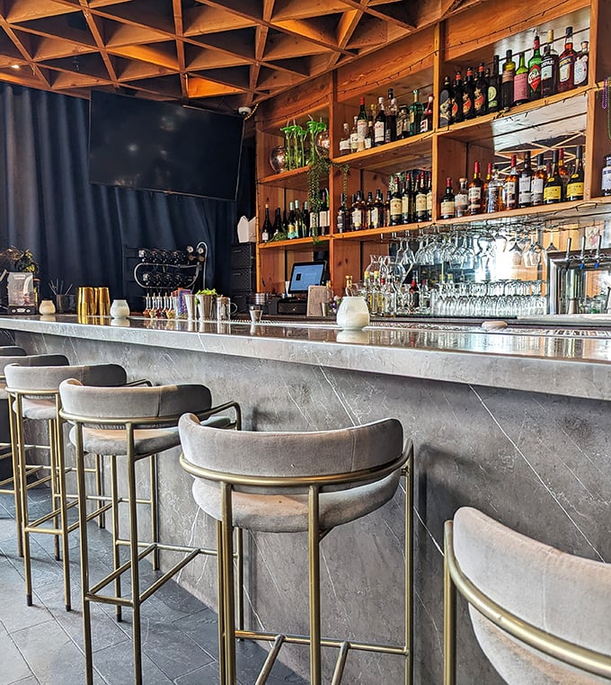 Those velvet bar stools aren't just stylish—they're an invitation to settle in for a proper Sazerac and forget about rush hour entirely.