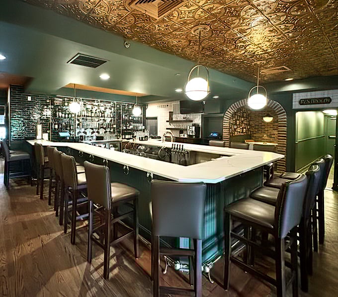 The bar's ornate ceiling gleams like the inside of a treasure chest, while comfortable seating invites you to claim your spot.