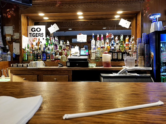 At the heart of this small-town bar, the counter tells its own story—lined with bottles of every kind.