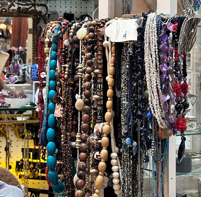 A rainbow of beads cascades like a tactile waterfall—turquoise, wood, and gemstone necklaces waiting to transform an outfit from ordinary to statement-making.