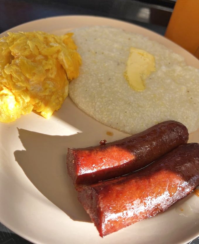 Sunshine on a plate: fluffy scrambled eggs, buttery grits, and sausage links with the perfect snap – breakfast doesn't get more honest than this.