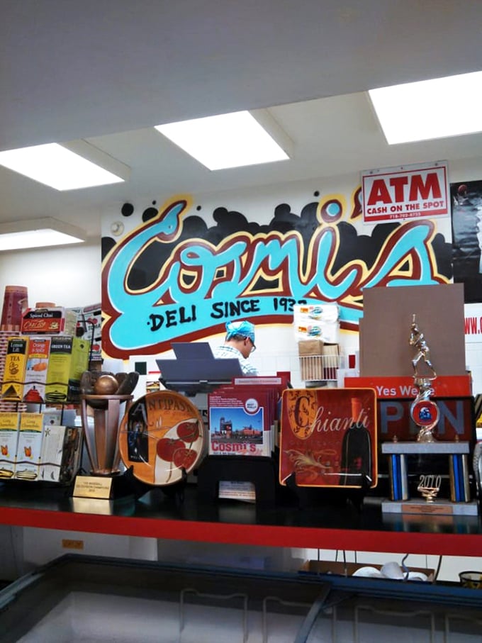 Behind the counter, where sandwich magic happens daily. The colorful mural reminds you this isn't just a deli—it's a Philadelphia institution.