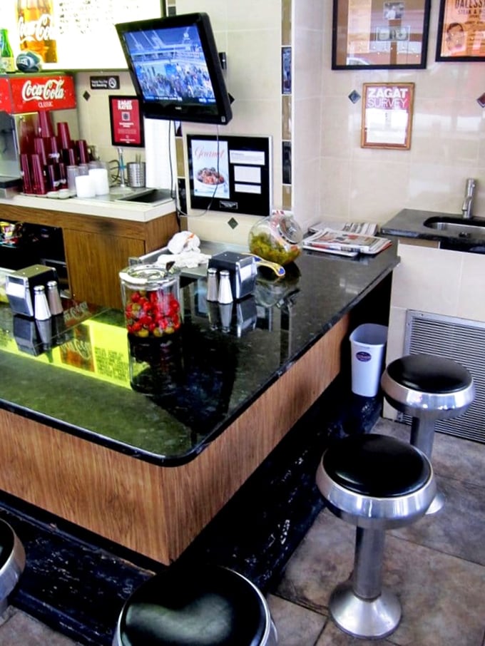 The counter – hallowed ground where sandwich dreams materialize. Those stools have supported the weight of countless happy customers and their impending food comas.