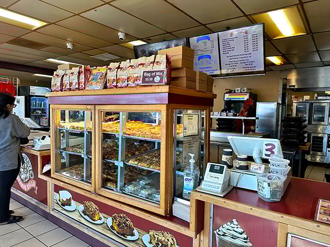 The display case: a glass-fronted museum of carbohydrate artistry. Each shelf a different exhibit in the gallery of "Things Worth Breaking Your Diet For."
