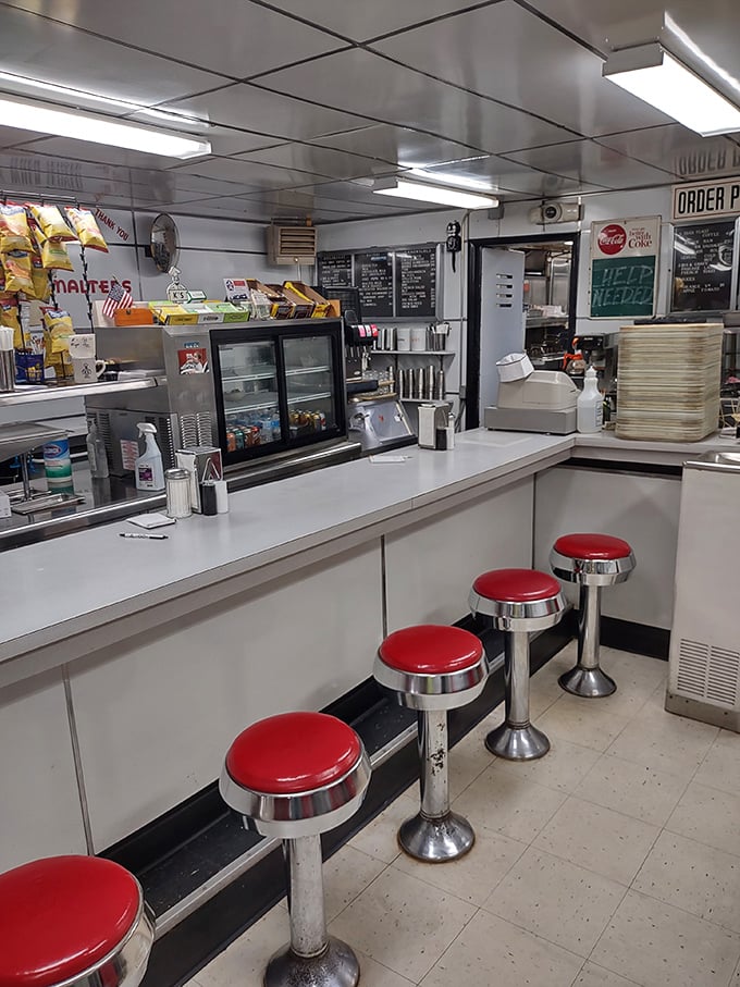 The counter where magic happens—classic red stools invite you to sit and watch short-order choreography that's been perfected over decades.
