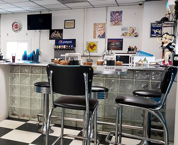 The counter where magic happens – chrome, glass blocks, and black-and-white checkered floors creating the perfect stage for breakfast theater.