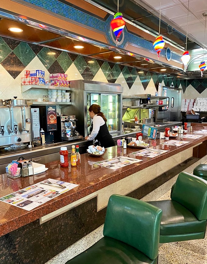 The counter – diner diplomacy in action, where strangers become temporary neighbors united by coffee and the morning paper.