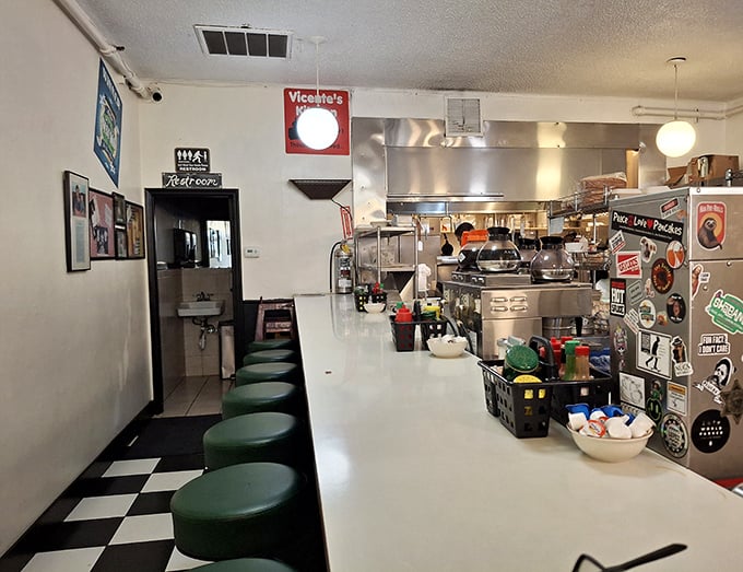 The green counter stools aren't just seating—they're front-row tickets to the greatest show on earth: watching short-order cooks perform breakfast ballet.