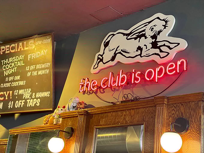 "The club is open" glows in neon, featuring the cafe's signature rabbit. A whimsical beacon for hungry souls seeking comfort food salvation.