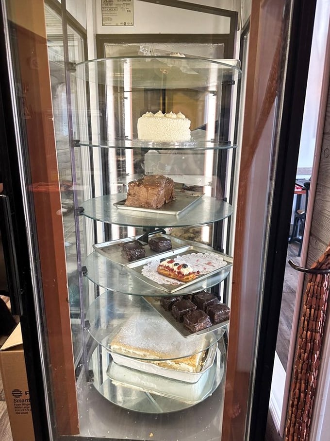 The dessert case—where willpower goes to die. Each shelf offers sweet temptation that makes "just looking" the biggest lie you'll tell yourself today.