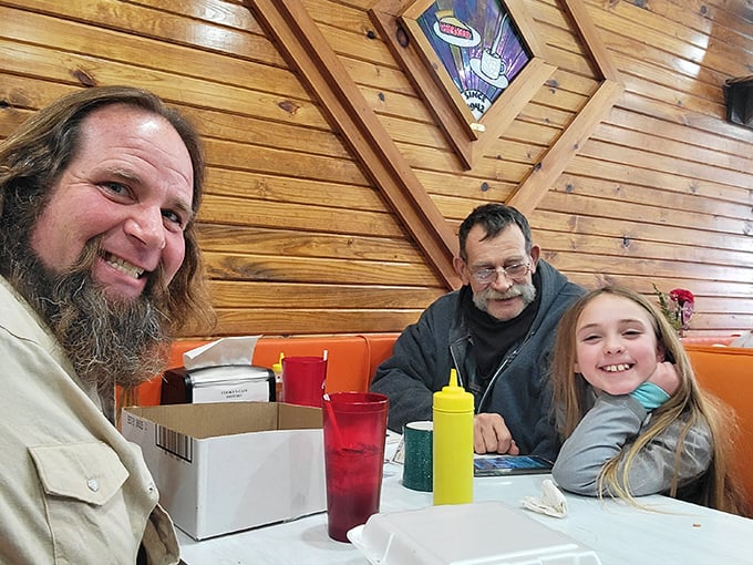 Happy diners enjoying the warm atmosphere and hearty food—creating memories that will bring them back to these orange booths time and again.