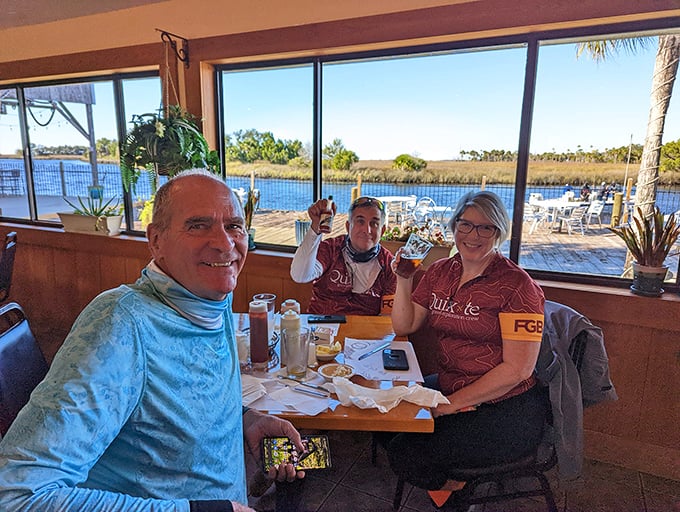 Happy diners with waterfront views—the universal expression of people who've just discovered their new favorite restaurant.