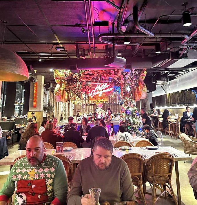 The dining room buzzes with the energy of shared discovery—each table embarking on their own culinary adventure under the glow of pink neon.