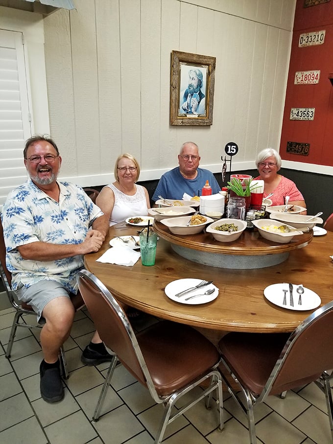 Happy diners gathered around a lazy Susan loaded with Southern delights—this is what Sunday dinner is supposed to look like.