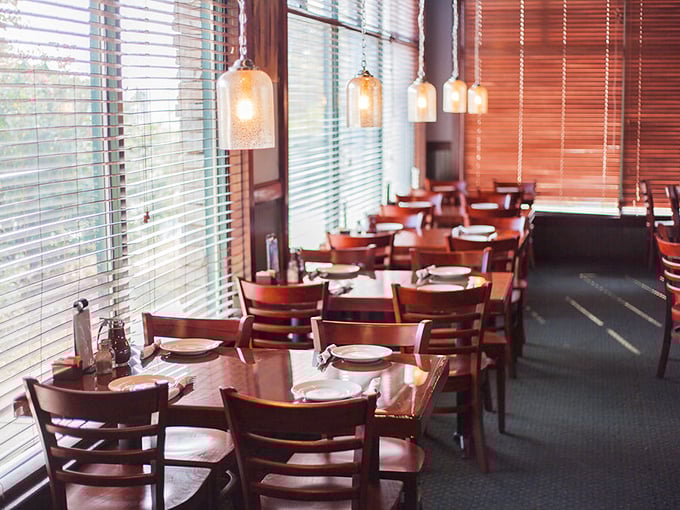 Pendant lights cast a warm glow over wooden tables, creating the perfect setting for important life decisions—like ribeye versus porterhouse.