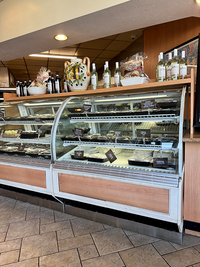 The dessert case—a glass-enclosed museum of sweet temptations that makes saying "I'm too full for dessert" the biggest lie you'll tell today.