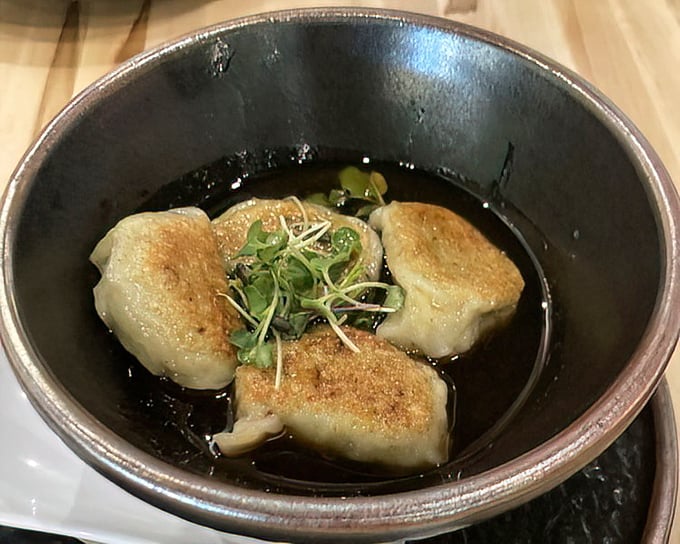 These dumplings aren't merely sitting in sauce—they're luxuriating in it, like tiny edible spa-goers enjoying their hot tub moment.