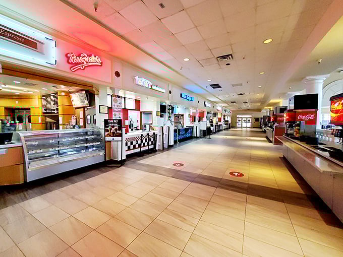The food court stands eerily quiet before opening, like a theater stage awaiting its daily performance of hungry shoppers seeking sustenance between stores.