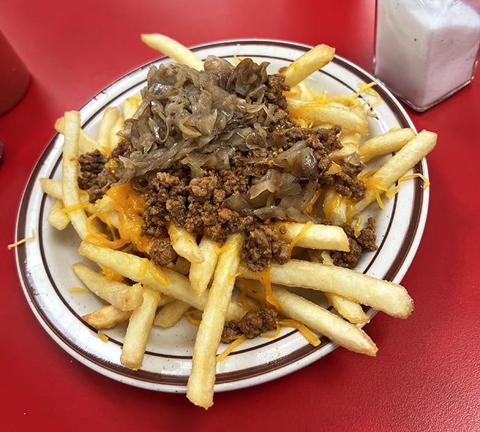 Cheese fries topped with chili and grilled onions—where every forkful is a treasure hunt and every bite hits the comfort food jackpot.