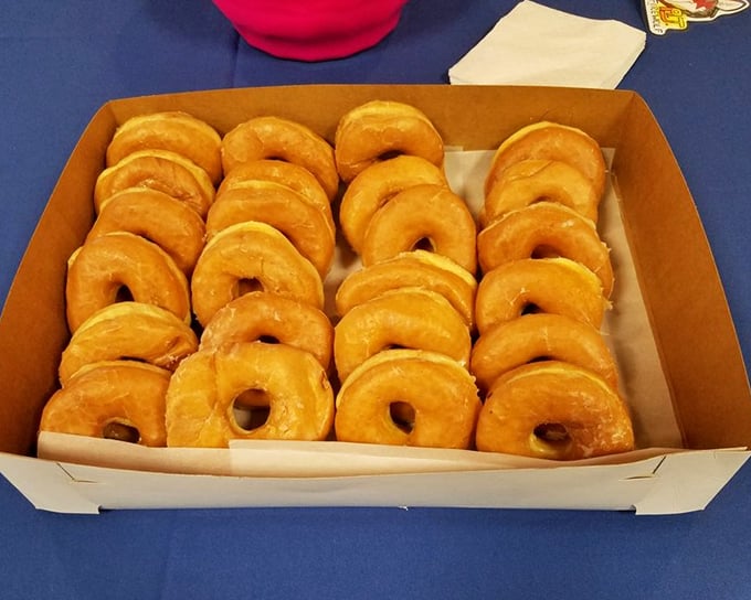 A box of glazed donuts lined up like soldiers—if soldiers were delicious, golden-brown, and caused spontaneous happiness rather than warfare.