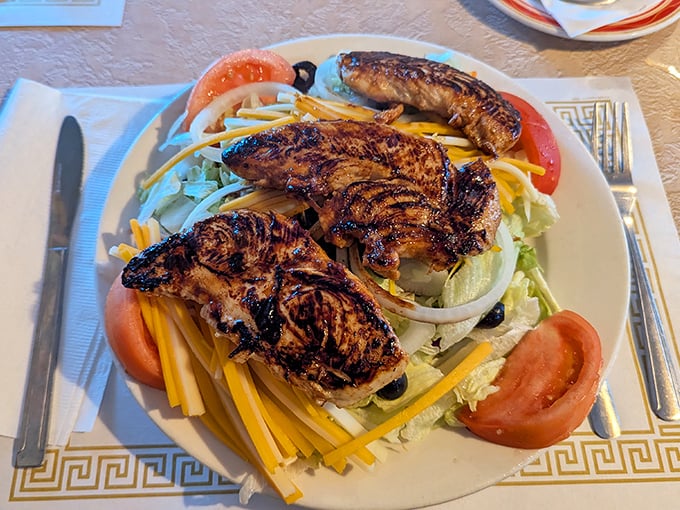 A salad that doesn't feel like punishment. Grilled chicken with actual grill marks atop a bed of cheese and veggies—healthy-ish never looked so good.