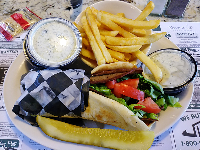 This isn't just a sandwich—it's a gyro that demands to be respected, with meat, sauce, and a pickle standing guard like it knows how good it is.