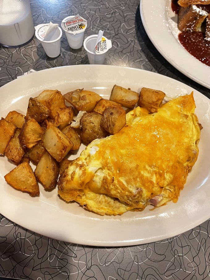 Ham and cheese omelet so fluffy it defies gravity, served with perfectly golden breakfast potatoes.
