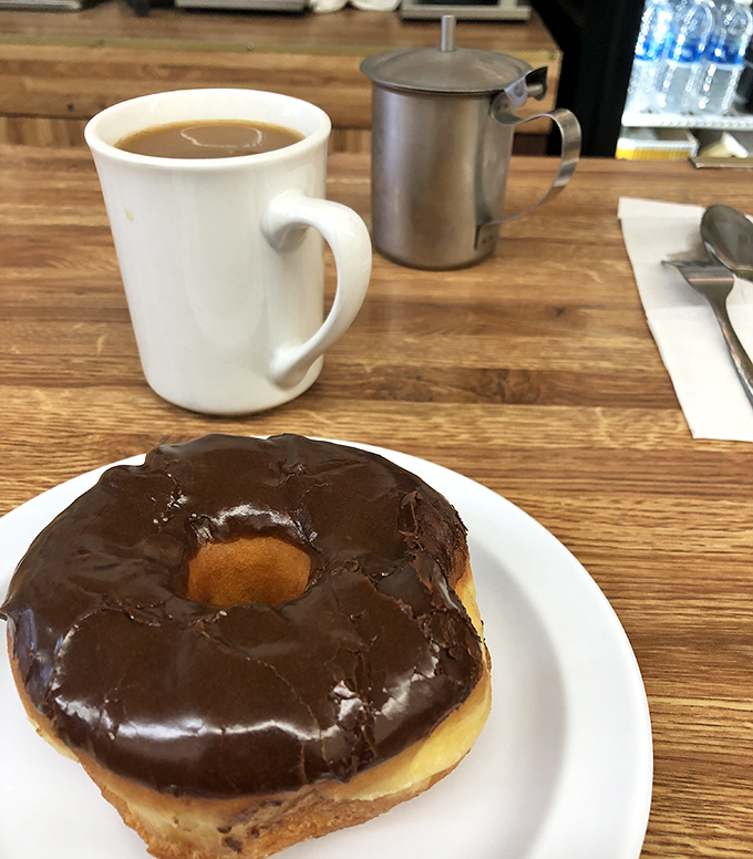 The perfect pairing: a chocolate donut and coffee. Name a more iconic duo—I'll wait while you contemplate this harmony of flavors.