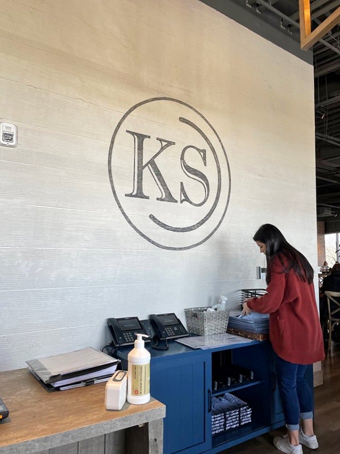The minimalist "KS" logo against textured white walls – proof that sometimes the best restaurants whisper rather than shout.
