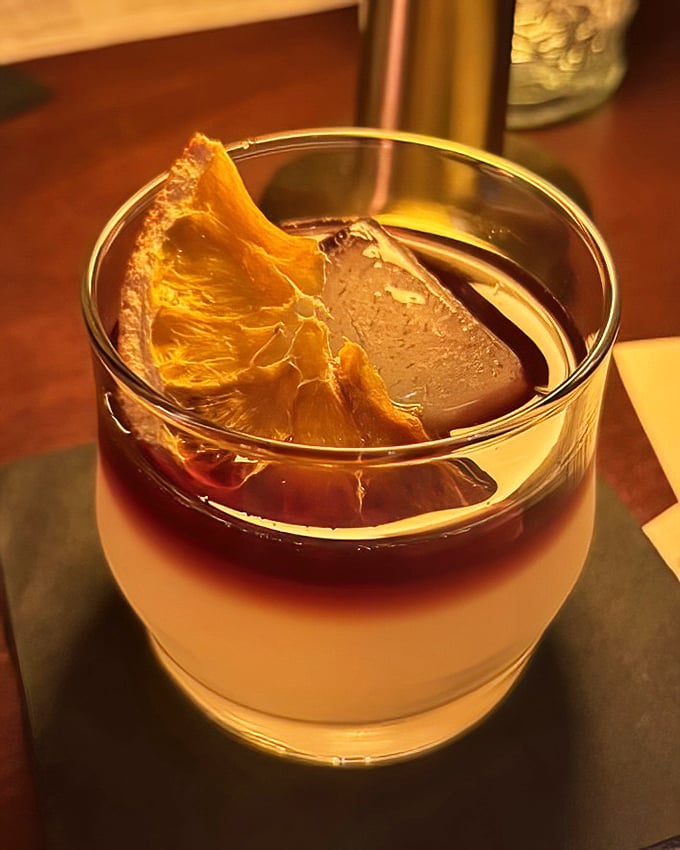 This cocktail isn't just a drink; it's a sunset in a glass with that dehydrated citrus slice serving as the perfect edible garnish.