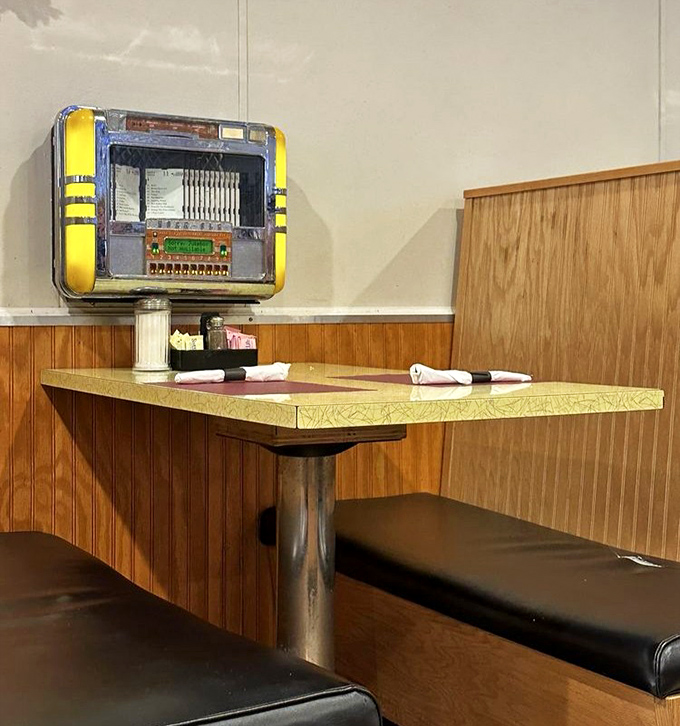 The vintage jukebox against wood-paneled walls reminds us that some dining traditions – like good music with good food – never go out of style.