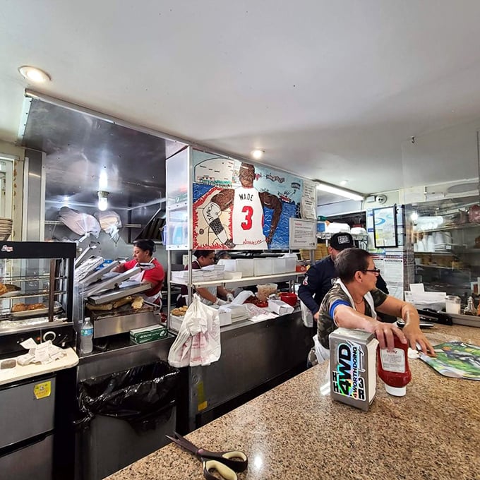 Behind the counter, where sandwich assembly becomes performance art and every order is handled with the precision of a NASA launch.