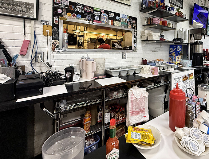 The kitchen pass—that magical portal where orders go in and breakfast dreams emerge, complete with a squeeze bottle of ketchup standing guard.