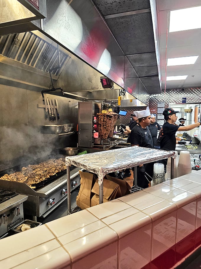 The kitchen crew in action—a choreographed dance of efficiency where tradition meets technique in a steam-filled ballet of taco creation.