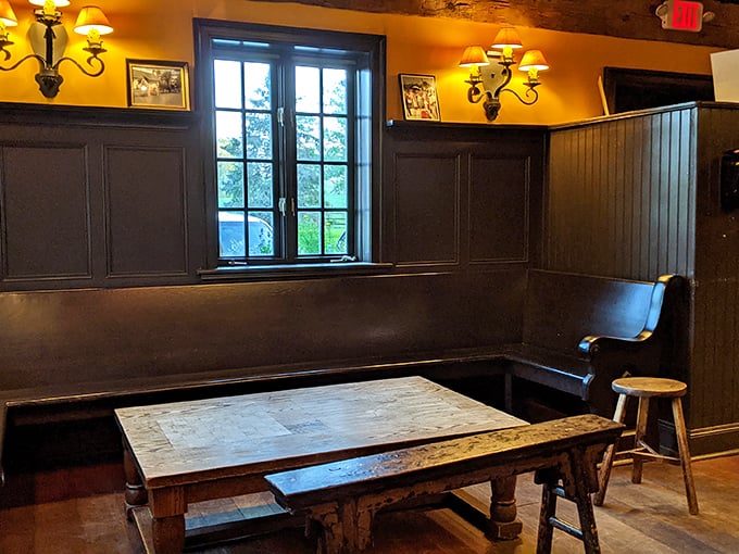 A corner table by the window – the most coveted real estate in the house. Dark wood paneling and bench seating create that authentic British pub atmosphere.
