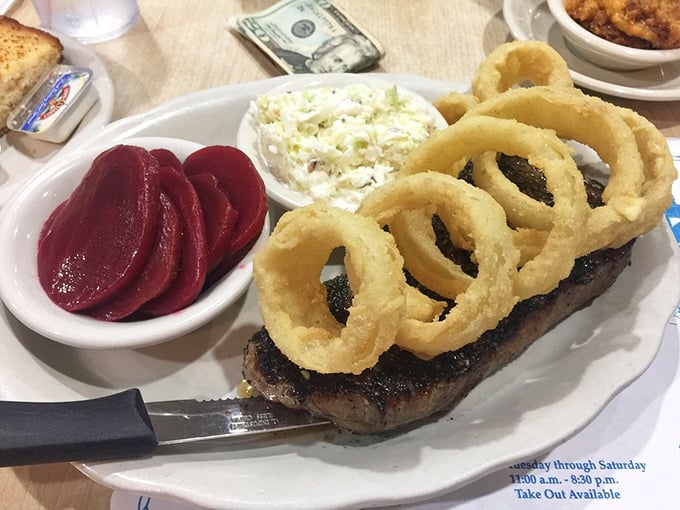 Even the steak gets the royal treatment, crowned with onion rings fit for seafood royalty. Those beets aren't just side dishes—they're ruby jewels.