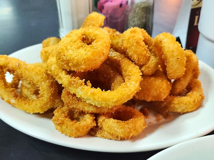 Onion rings stacked high like golden halos – crispy, not greasy, with that perfect "pull" when you bite in that separates the great from the merely good.