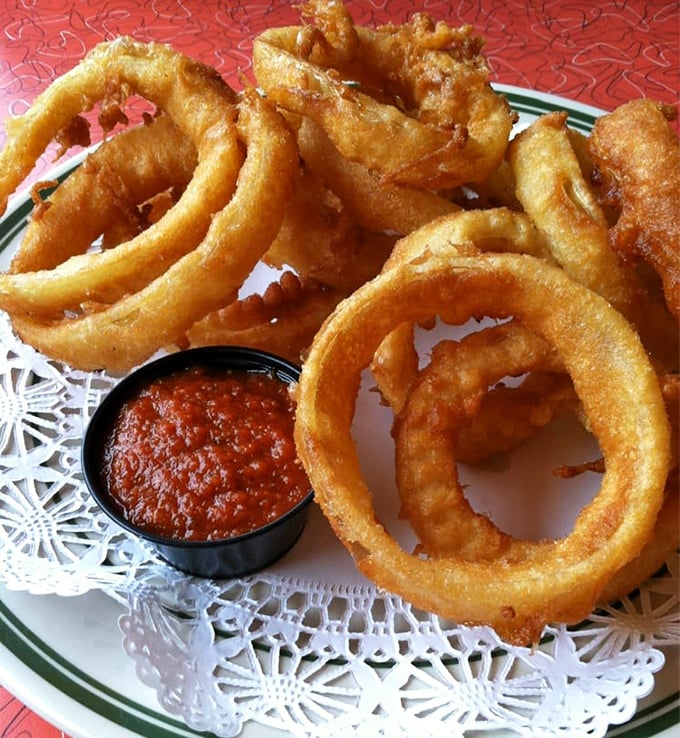 Onion rings that achieve the impossible: perfectly crisp exteriors giving way to sweet, tender onion within—the golden halos of the comfort food world.