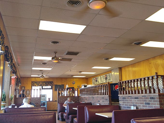 Ceiling fans lazily spin above wood-paneled walls and red booths, creating that perfect diner atmosphere where time slows down just enough to enjoy your meal.