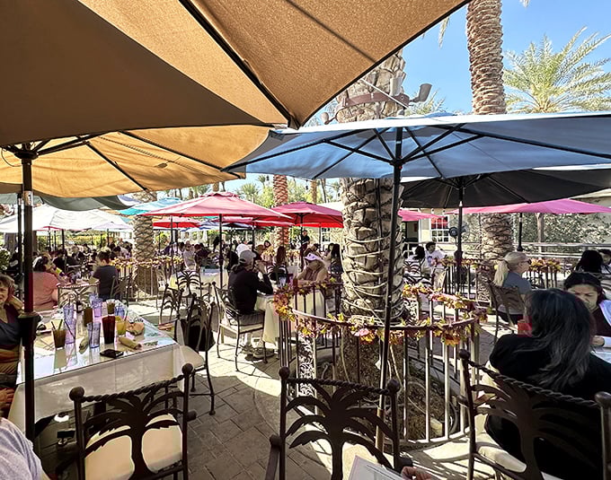 The bustling patio scene under colorful umbrellas proves that outdoor dining in the desert isn't just possible—it's practically mandatory.