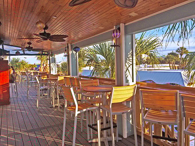 Paradise found: palm fronds frame this breezy porch where wooden chairs invite you to settle in and forget what day it is.