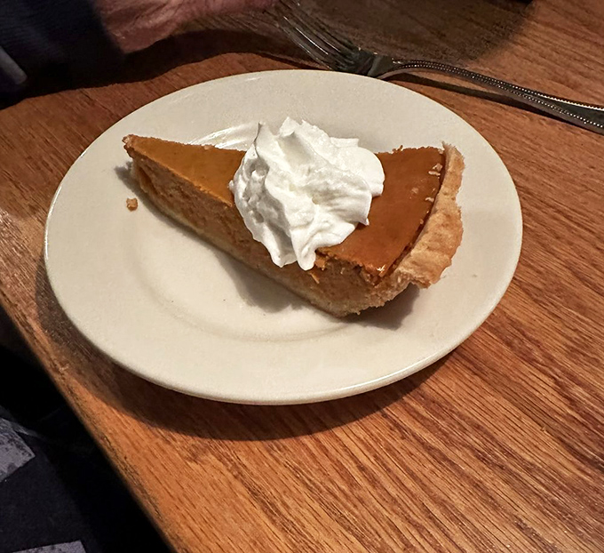 A slice of pumpkin pie that doesn't need to be seasonal to be spectacular—especially with that cloud of whipped cream on top.